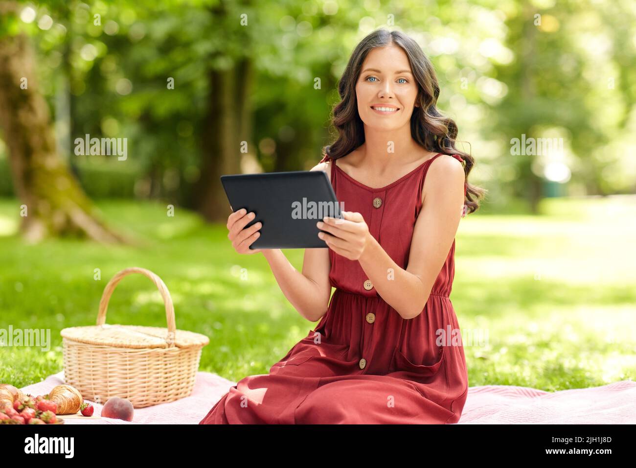 happy woman with tablet computer on picnic at park Stock Photo - Alamy
