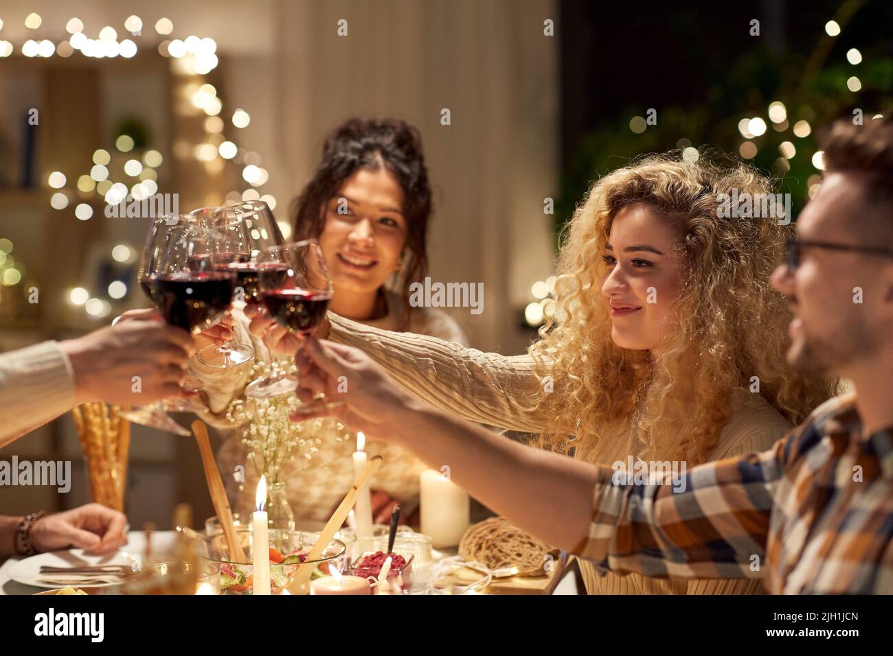 happy friends drinking red wine at christmas party Stock Photo - Alamy