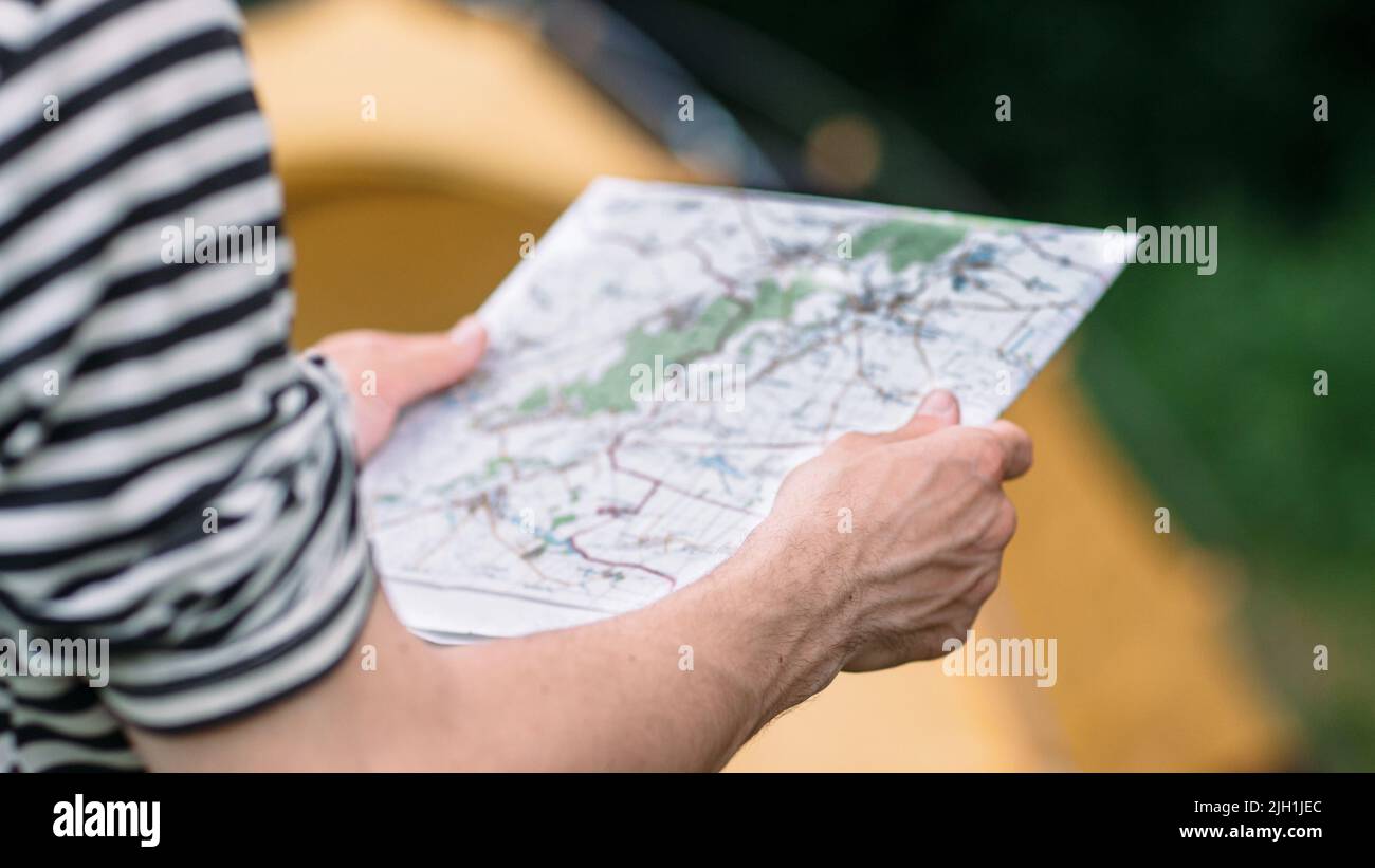 Tourist reading geographic map choosing best way Stock Photo - Alamy
