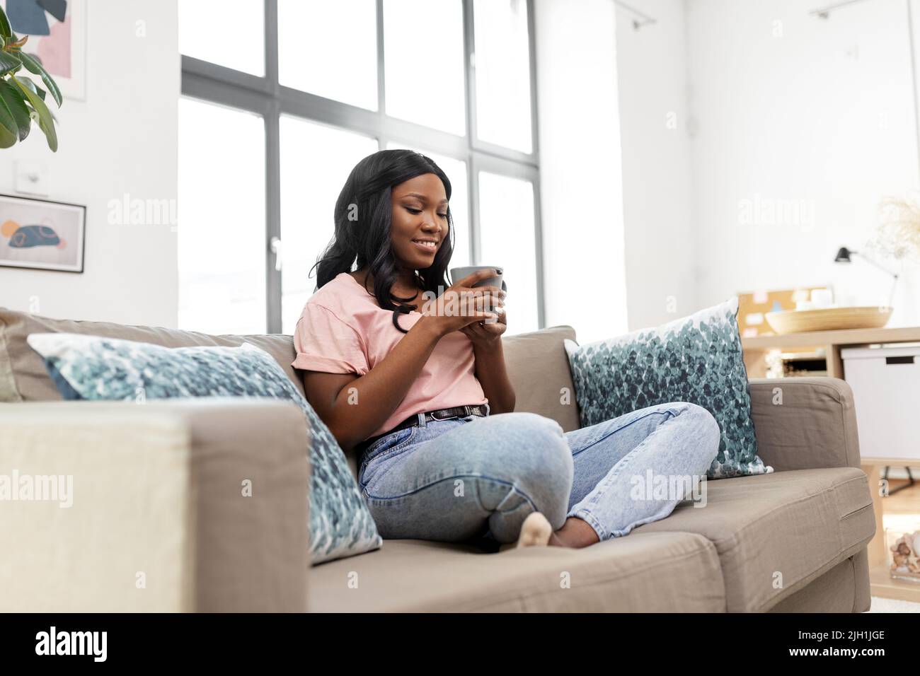 happy african woman drinking tea or coffee at home Stock Photo - Alamy