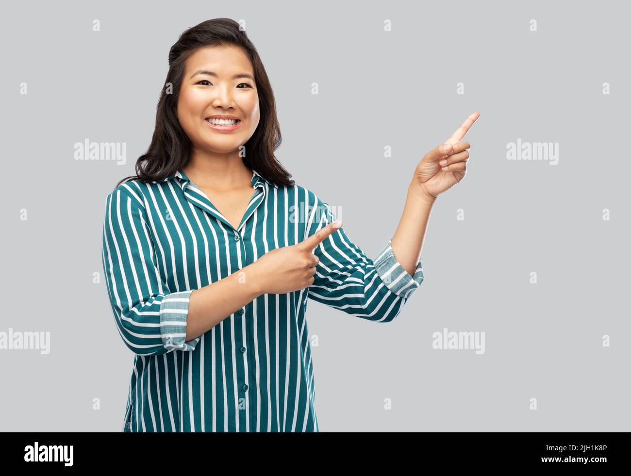 happy asian woman pointing fingers up on grey Stock Photo - Alamy