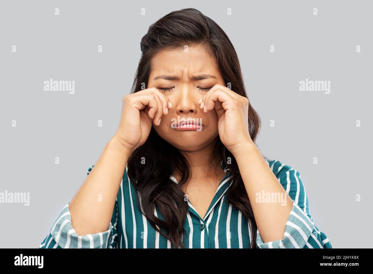 sad asian woman crying over grey background Stock Photo - Alamy