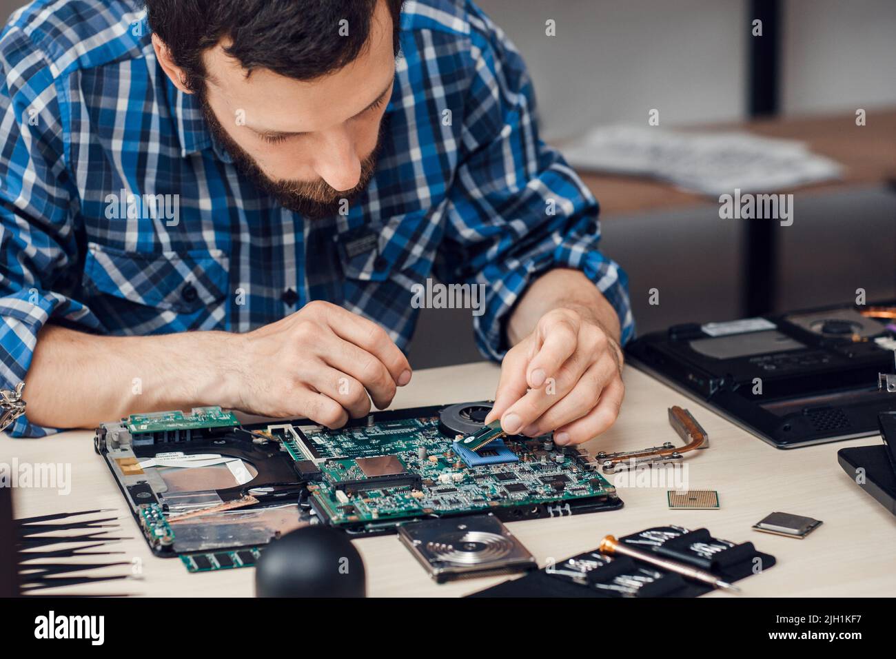 Repairman disassembling laptop motherboard Stock Photo - Alamy