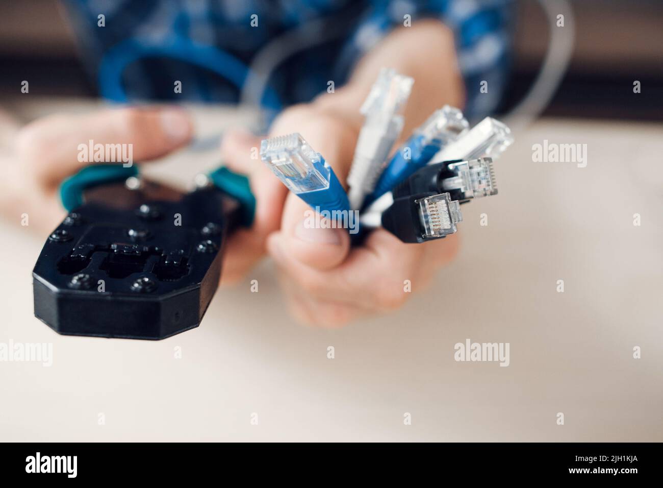 Hands holding cables and forceps for crimping plug Stock Photo - Alamy