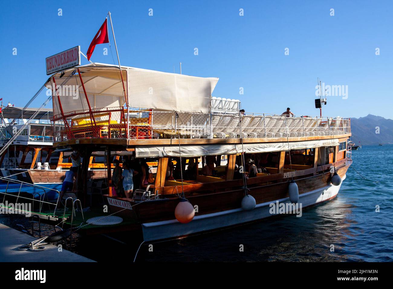 Pleasure yacht in the port. Tourist ship with people on board with turkish flag getting ready to ...