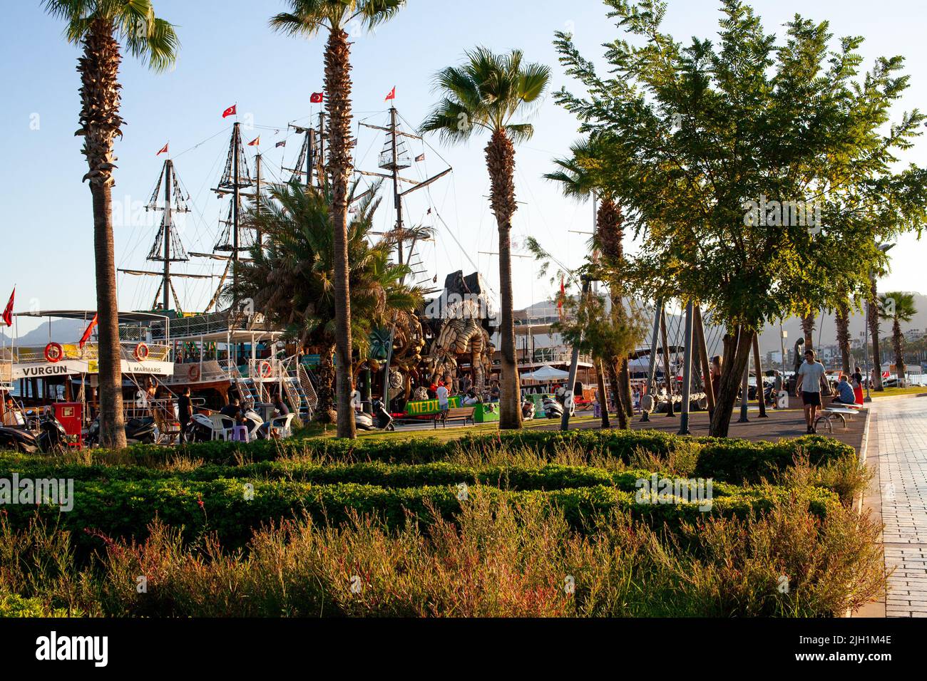 Tourists walk along the embankment of the resort town of Marmaris ...