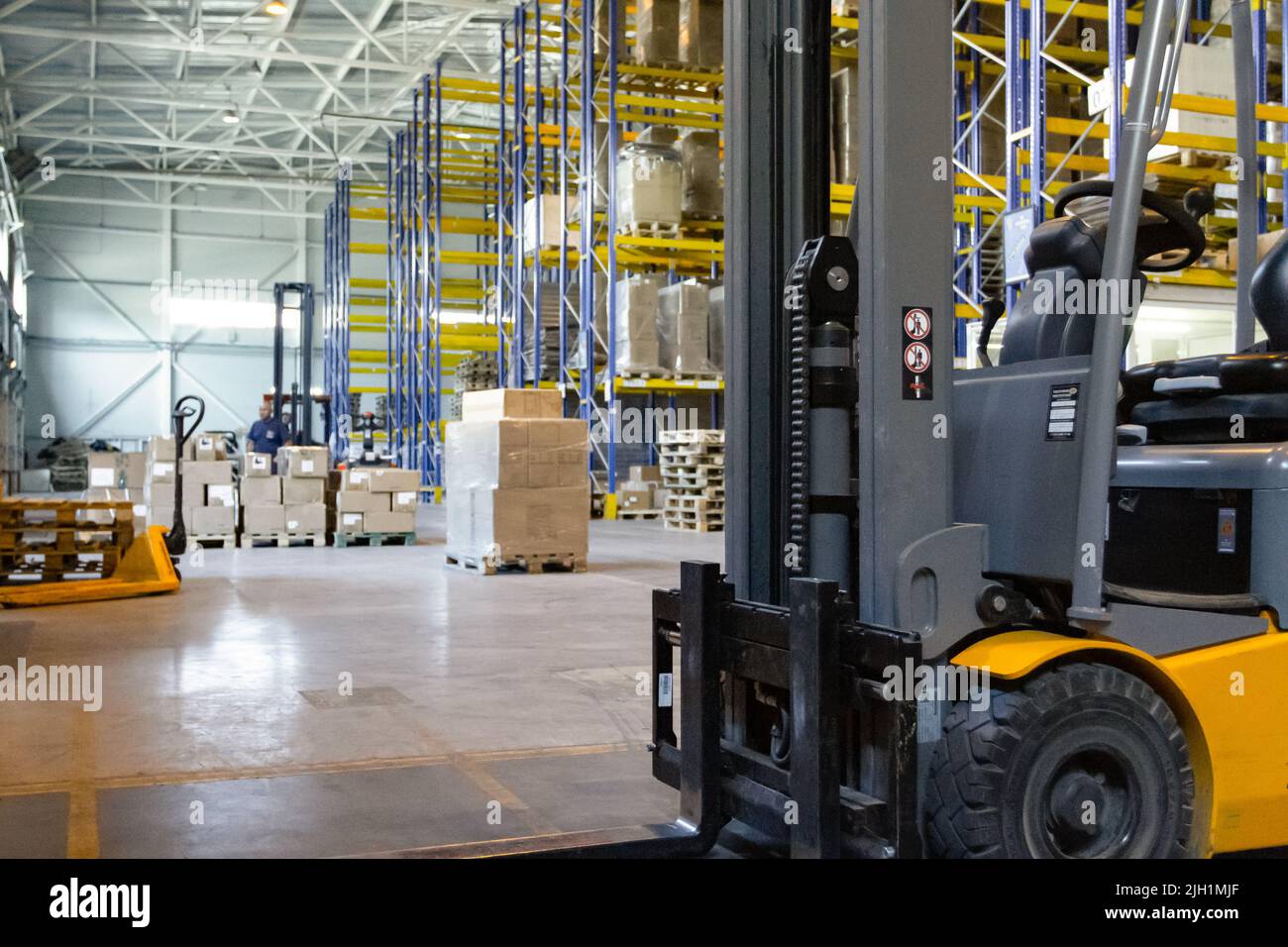 Interior of a modern warehouse with forklifts. Pallet stacker truck ...