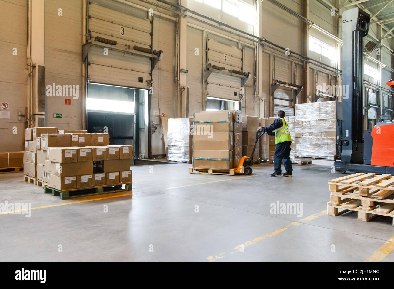 Interior of a modern warehouse storage of retail shop with pallet truck ...