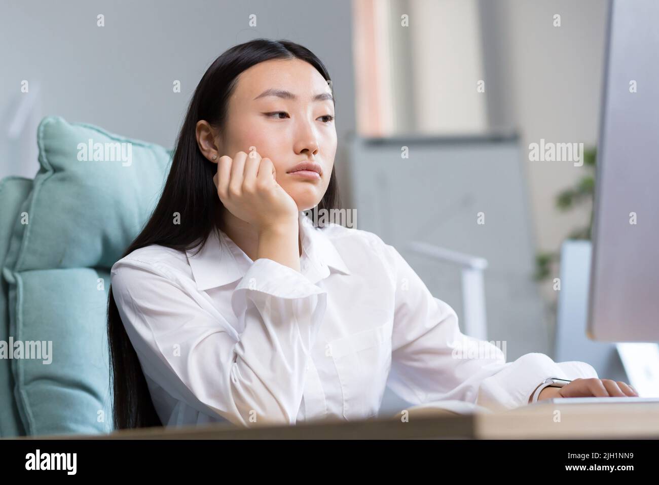 Boring and monotonous work. A young beautiful Asian business woman, an ...