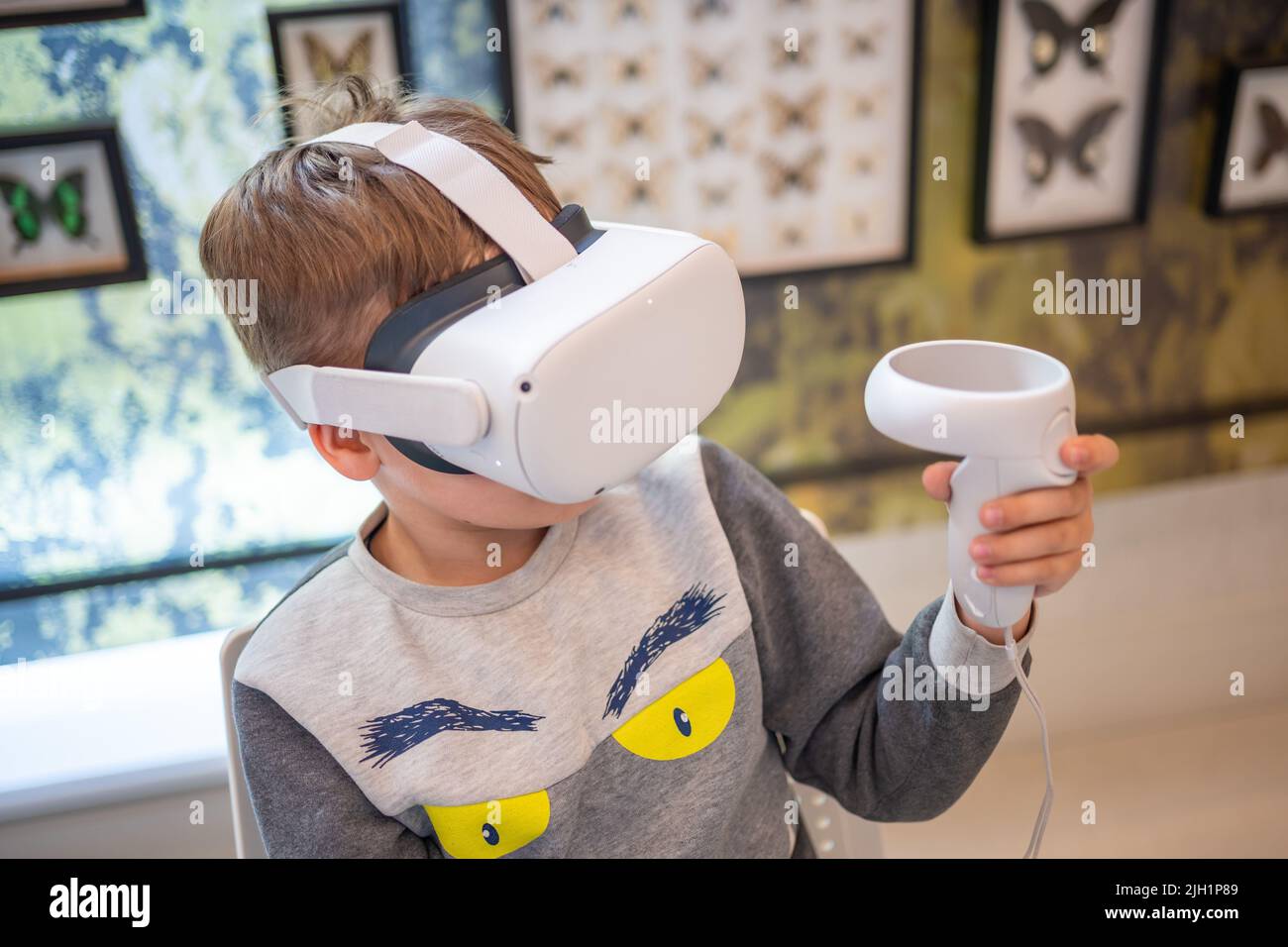 Kid wearing VR headset, moving hands and touching air. Boy playing ...