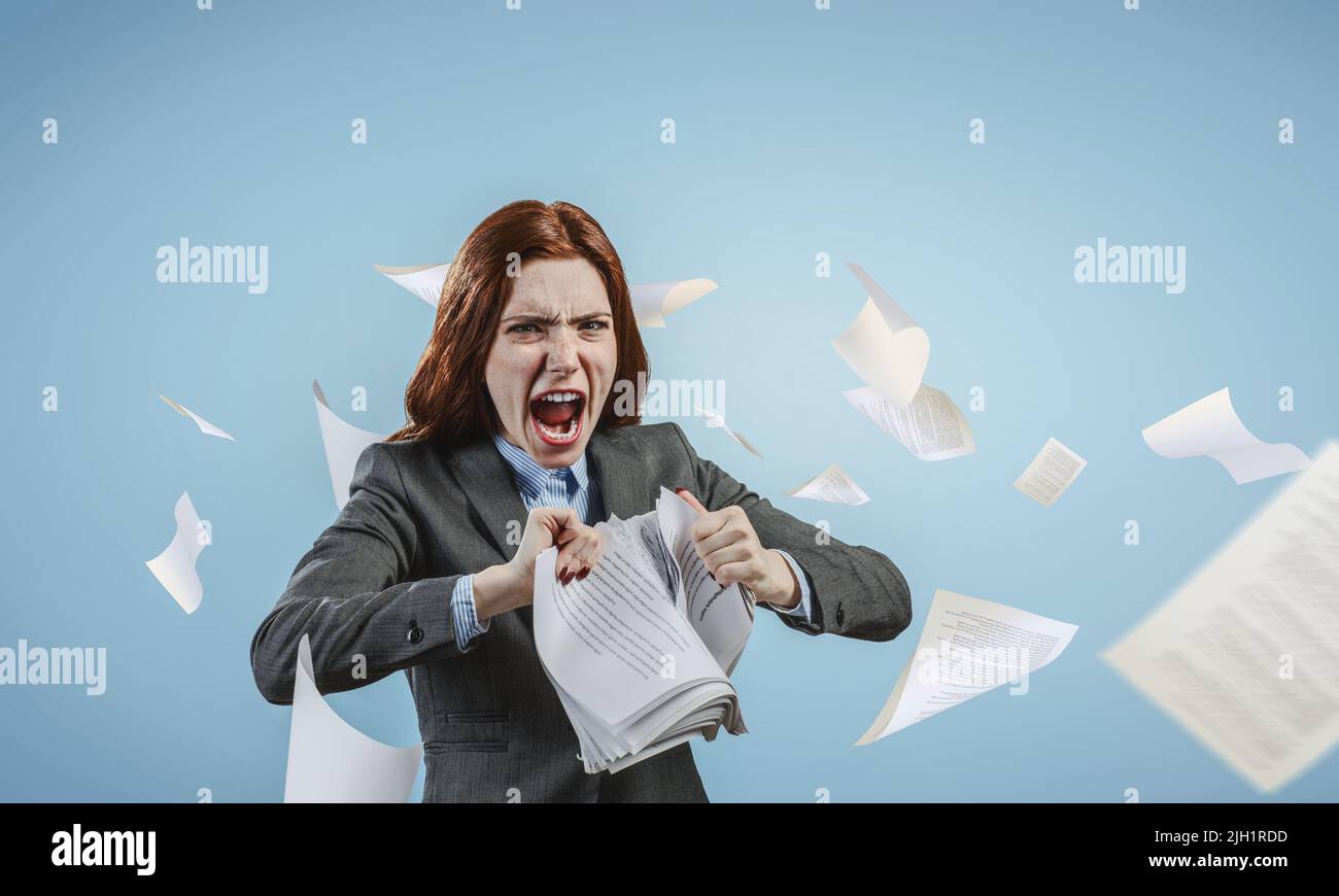 Young stressed woman ripping documents with frustrated facial ...