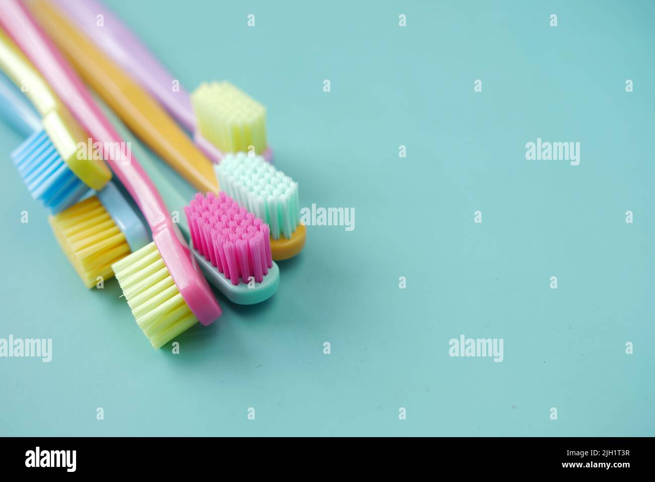 colorful toothbrushes on a light green background with copy space Stock ...