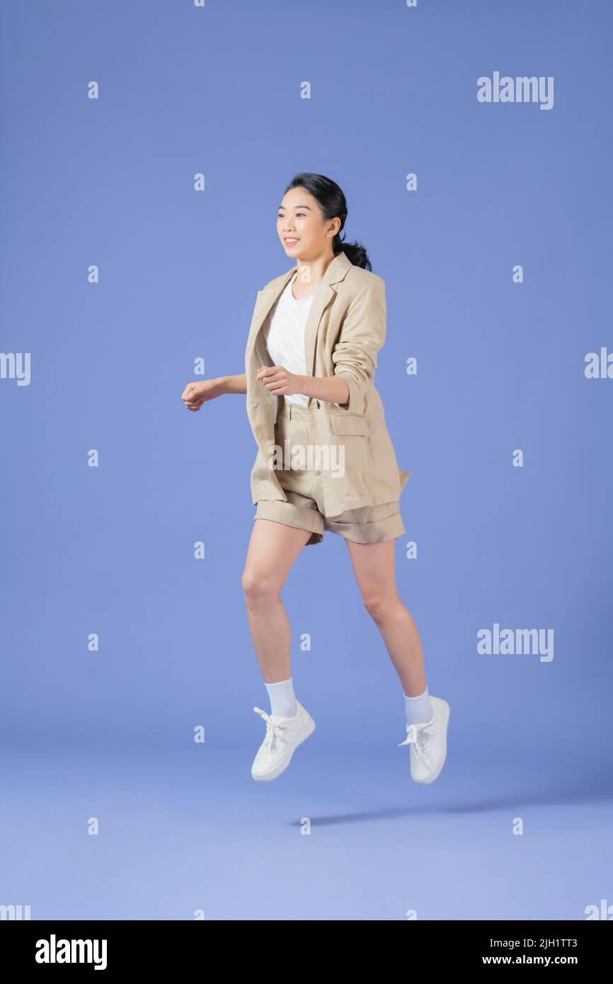 Photo of cute shiny young woman running looking back empty space ...