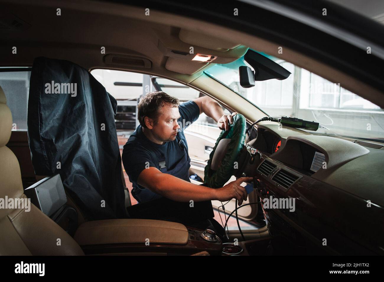 On-board computer tuning by serviceman at garage Stock Photo - Alamy