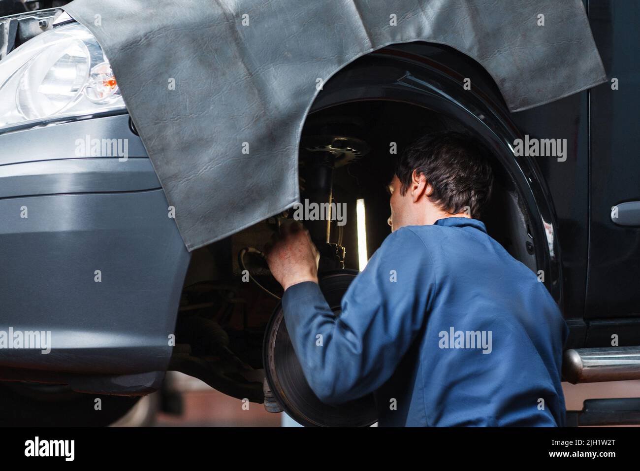 Mechanic inspecting car suspension system Stock Photo - Alamy