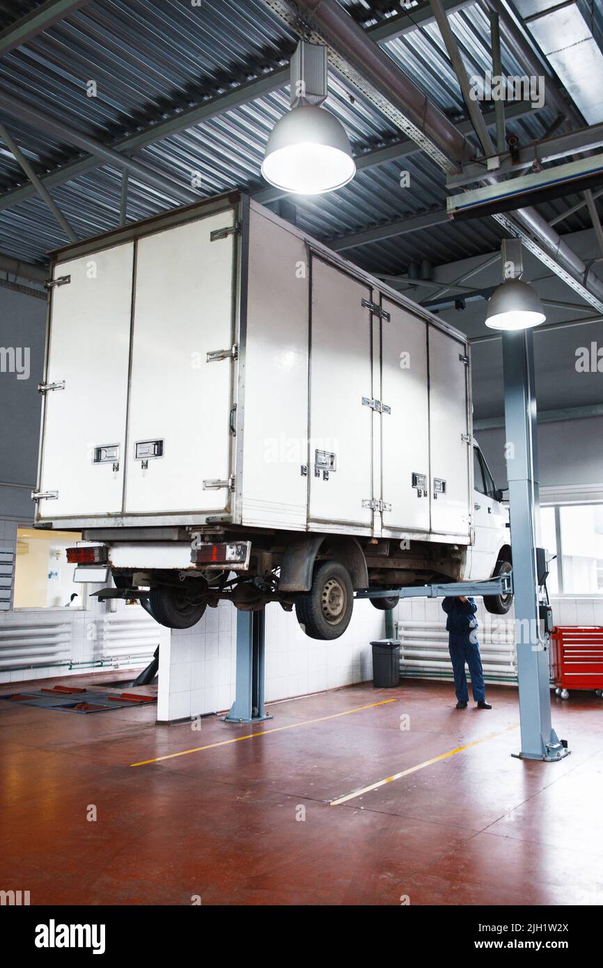 Truck service in garage, lifted lorry diagnostics Stock Photo - Alamy