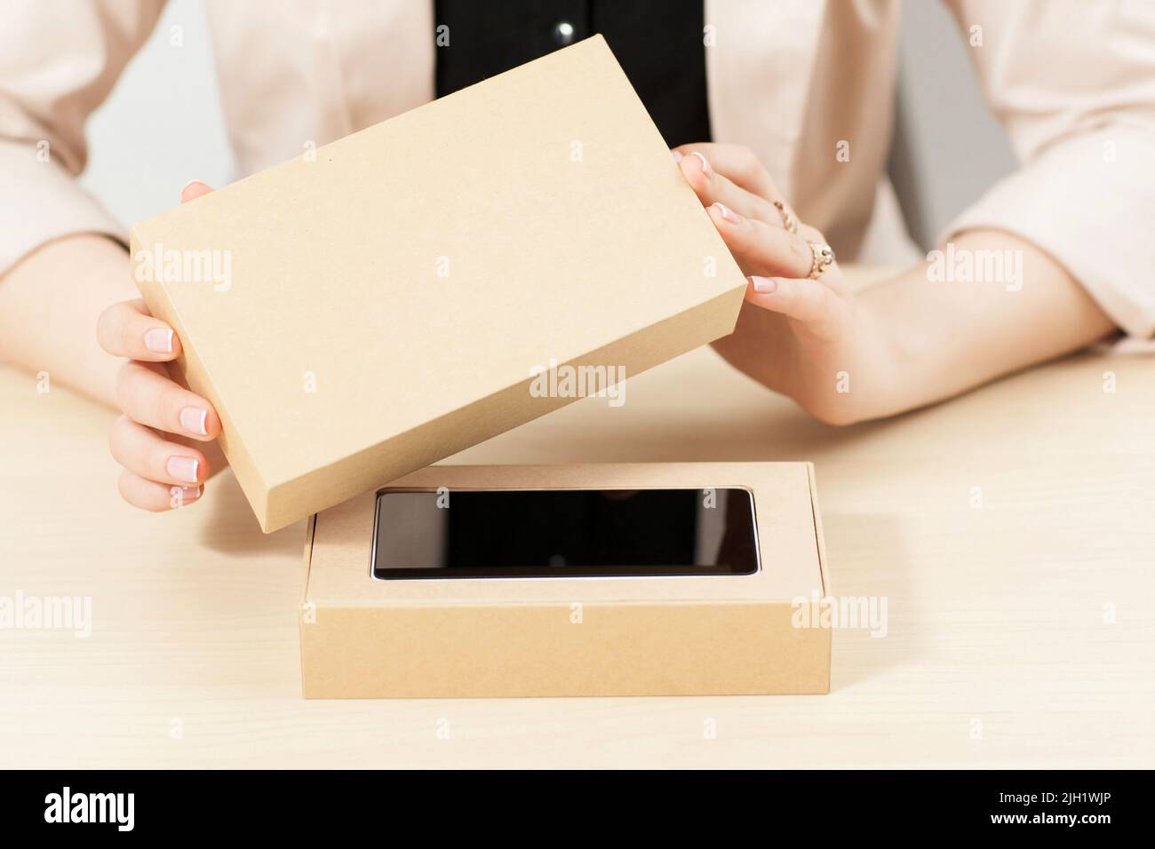 Woman opening box with new smartphone, close-up Stock Photo - Alamy