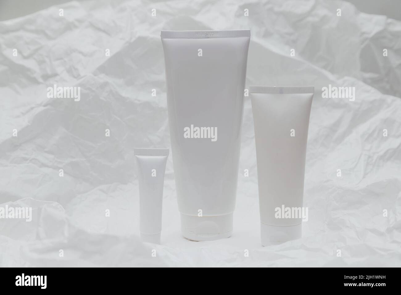 Three white blank lotion squeeze tubes or cosmetic bottles, different ...