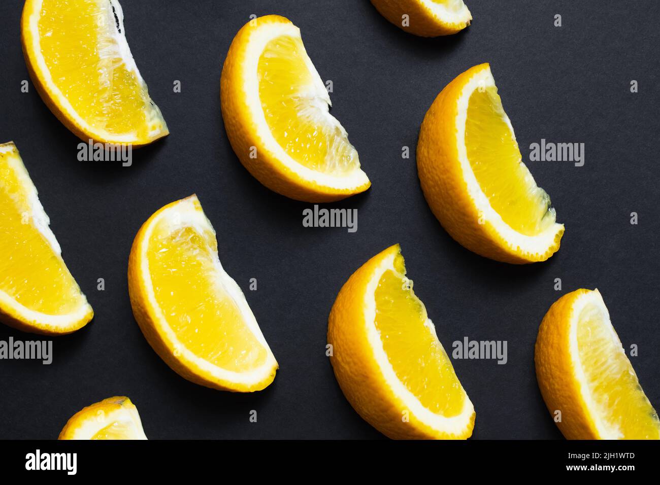 Flat lay with pieces of sweet oranges on black background Stock Photo ...