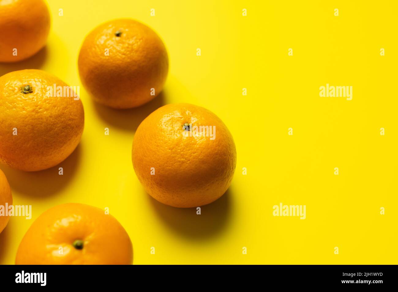 High angle view of sweet tangerines on yellow background Stock Photo ...