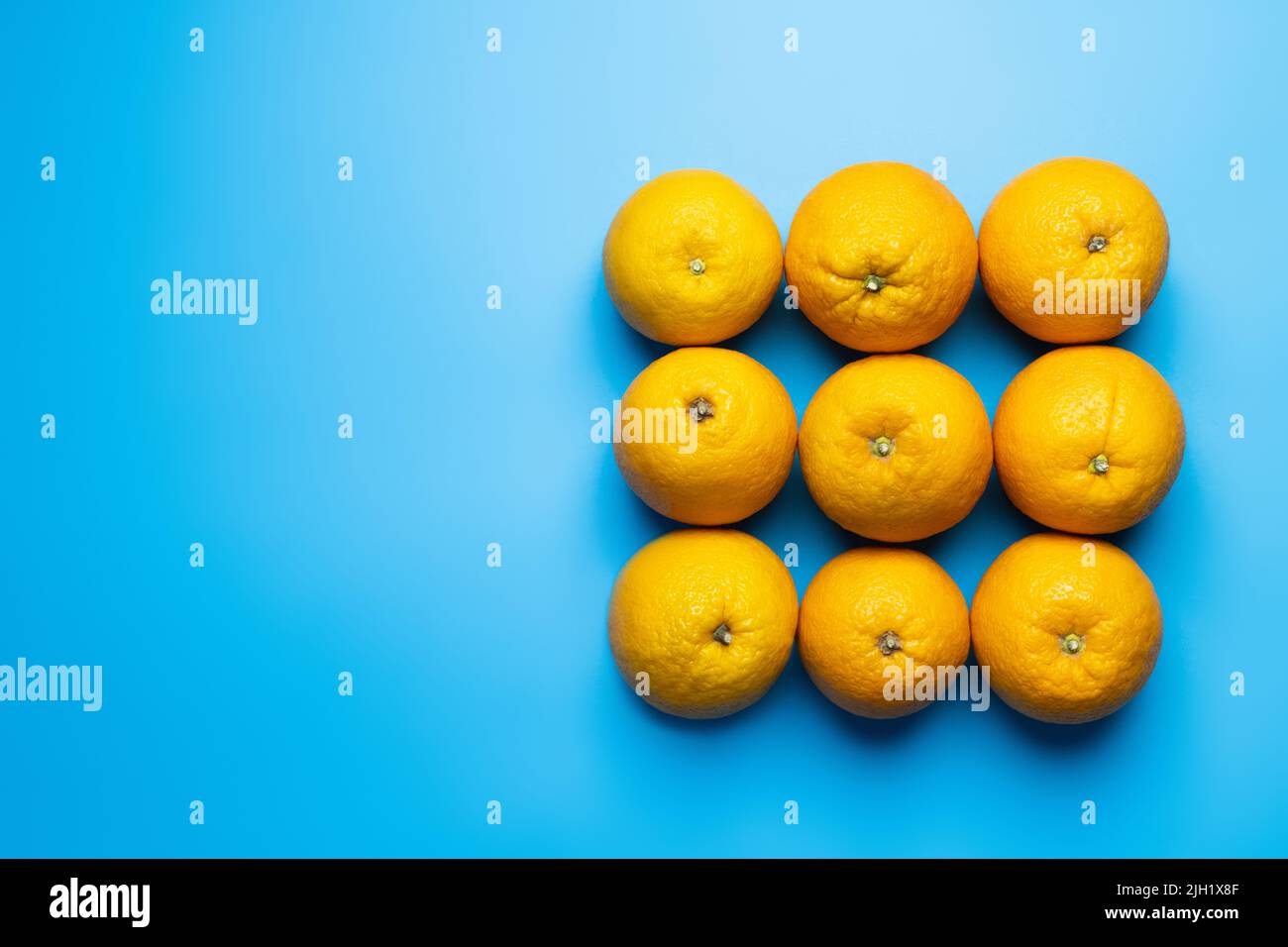 Flat lay with oranges in square shape on blue background Stock Photo ...