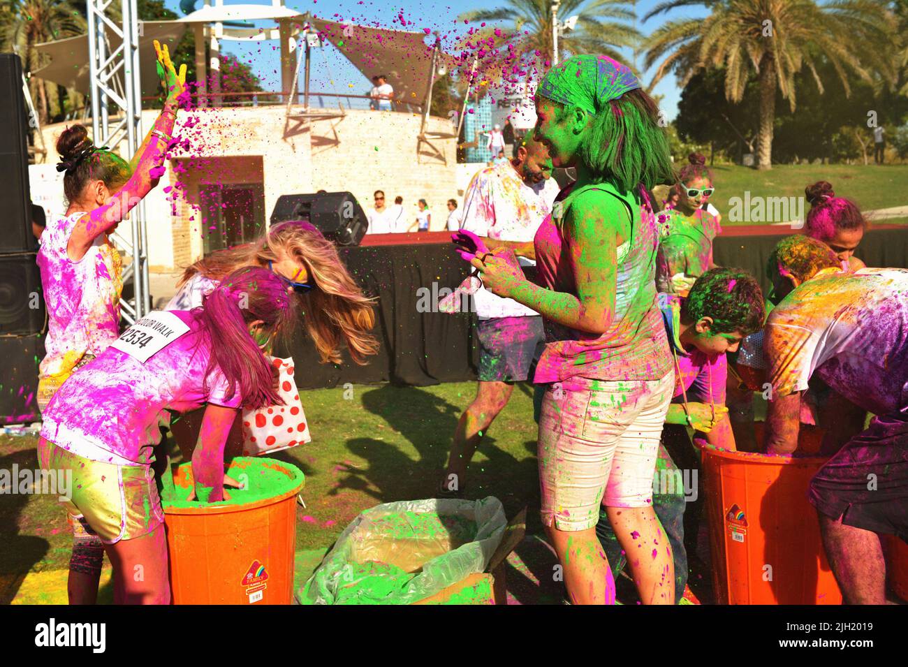 Young boys and girls happily grab and throw colored powder from big ...