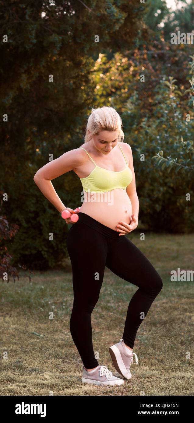 Fitness pregnant woman feeling her baby push Stock Photo - Alamy