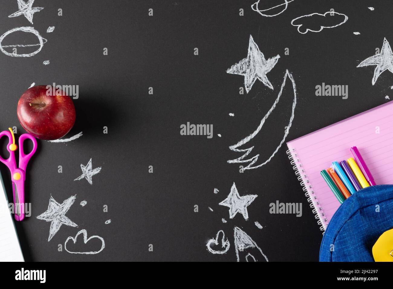 Image of school supplies, apple and notebook over drawings on black ...