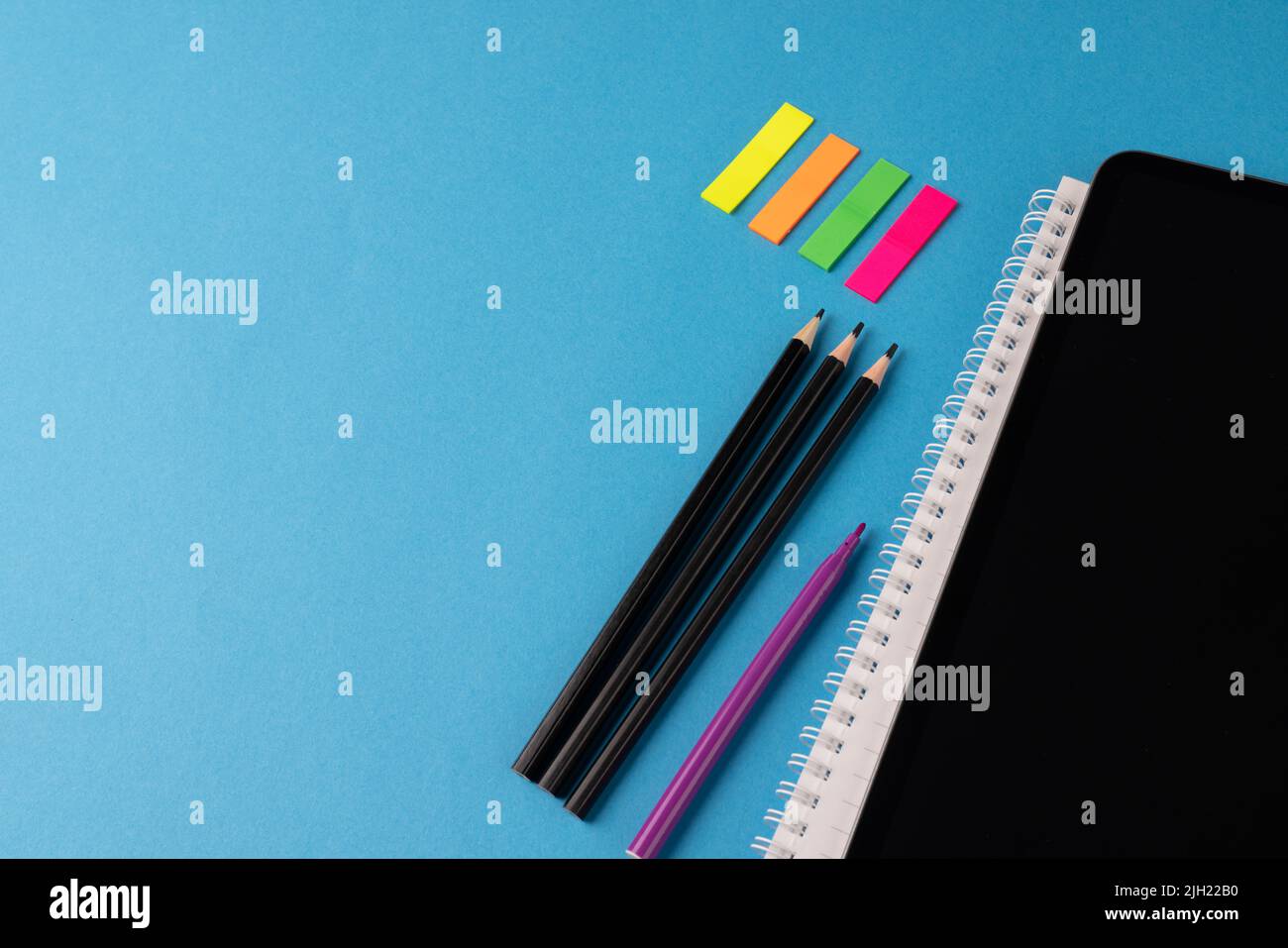 Image of various office supplies, pens and notebook on blue background ...