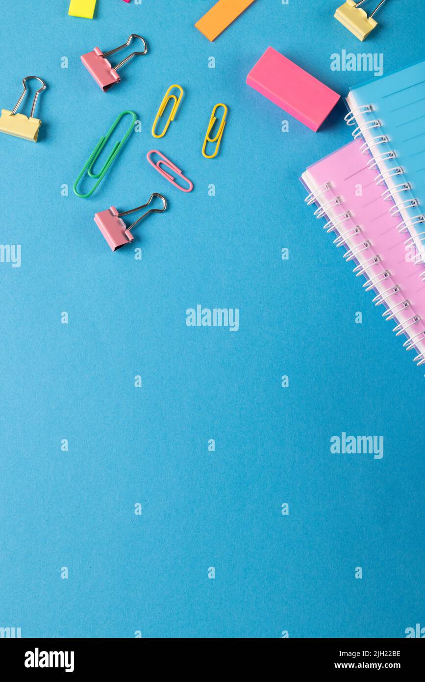 Image of various office supplies, paper clips, notebooks on blue ...