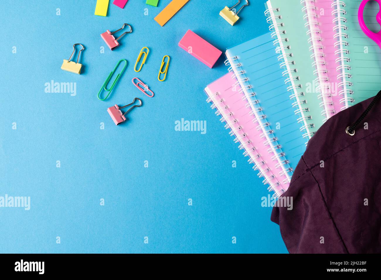 Image of various office supplies, paper clips, notebooks on blue ...