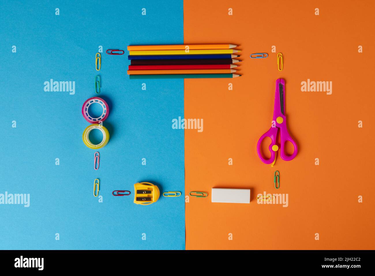 Composition of frame made of crayons, scissors and other items on blue ...