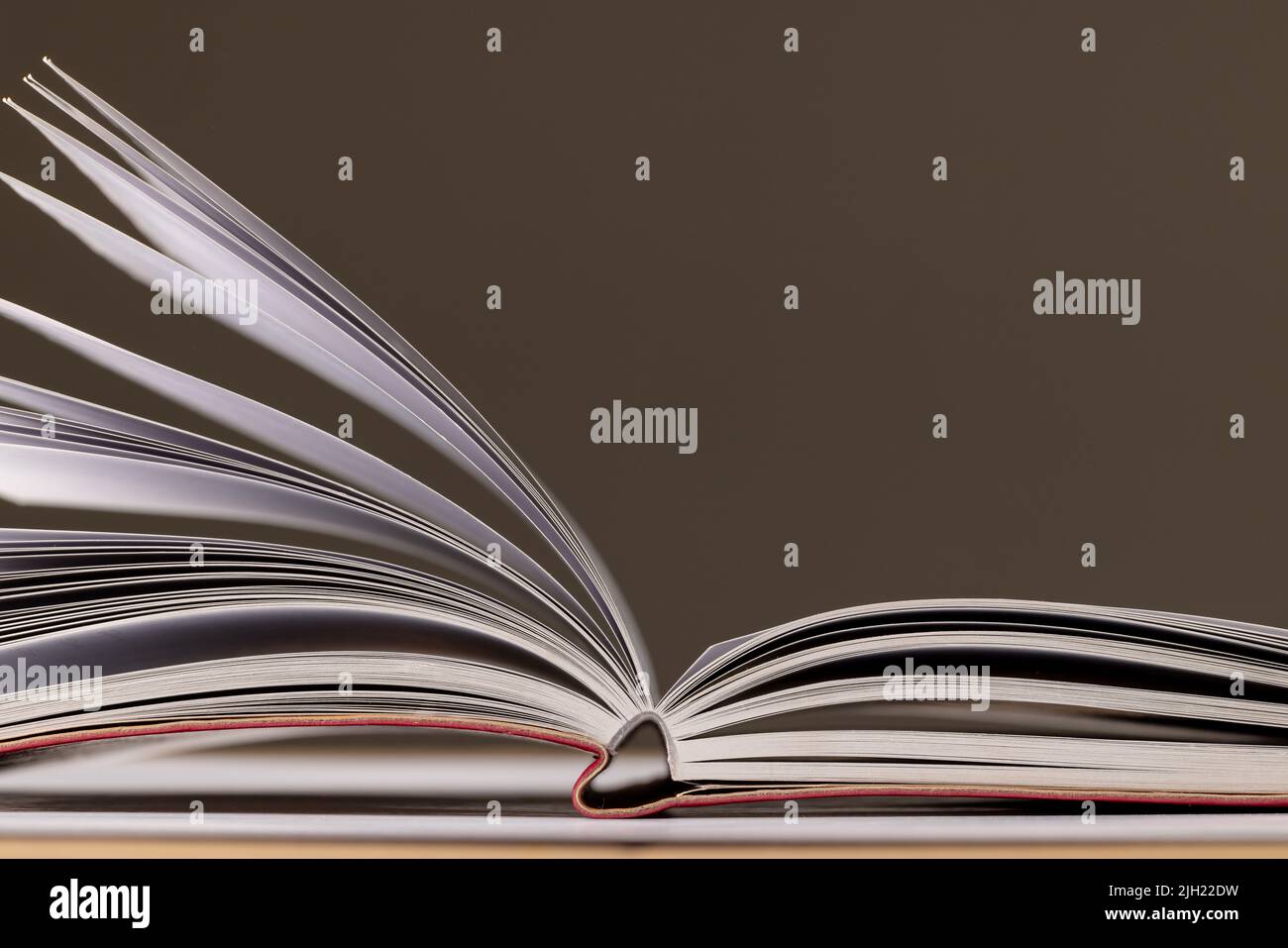 Image of open book lying on brown background Stock Photo - Alamy