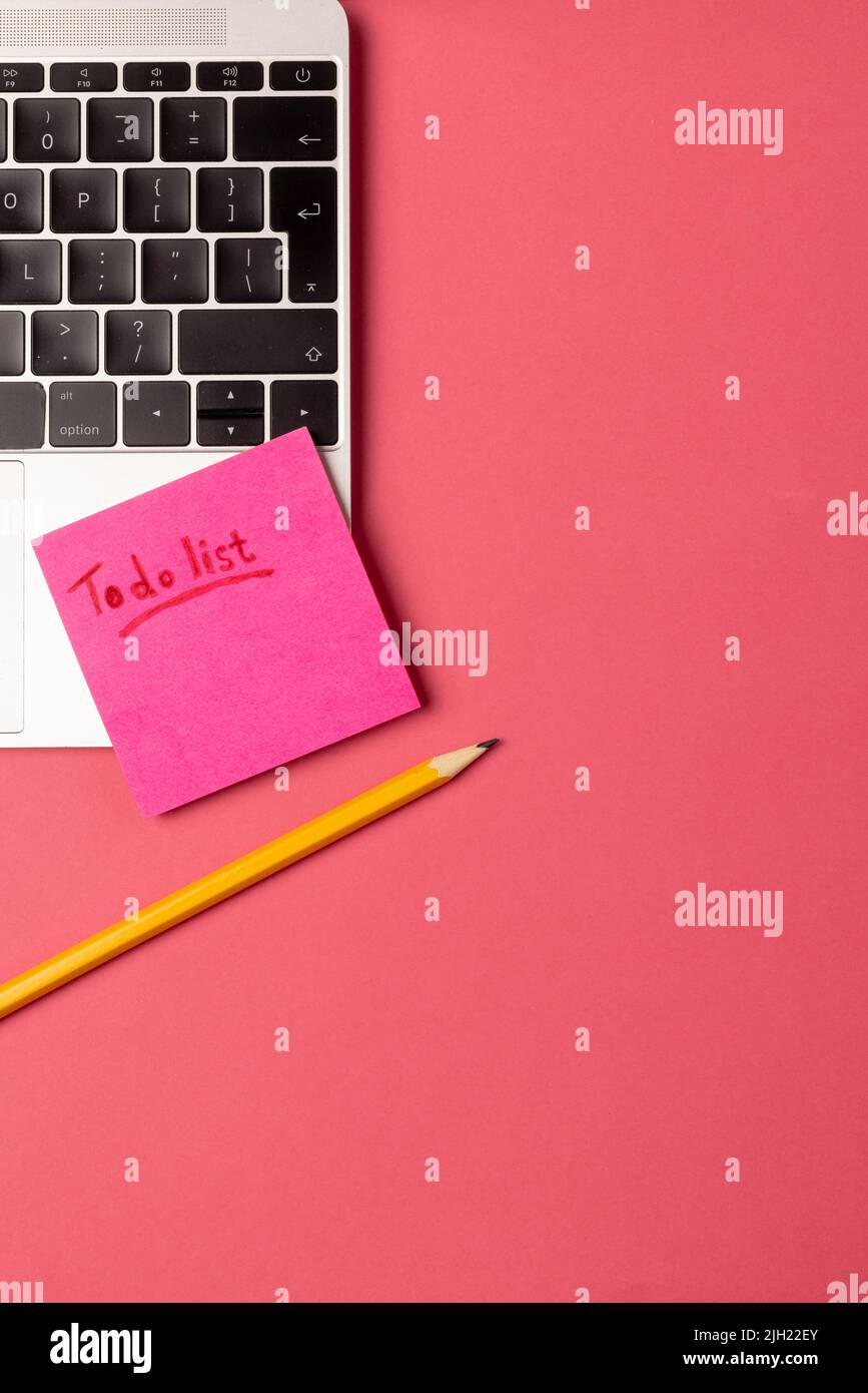 Vertical image of laptop, post it and pencil on red background Stock ...