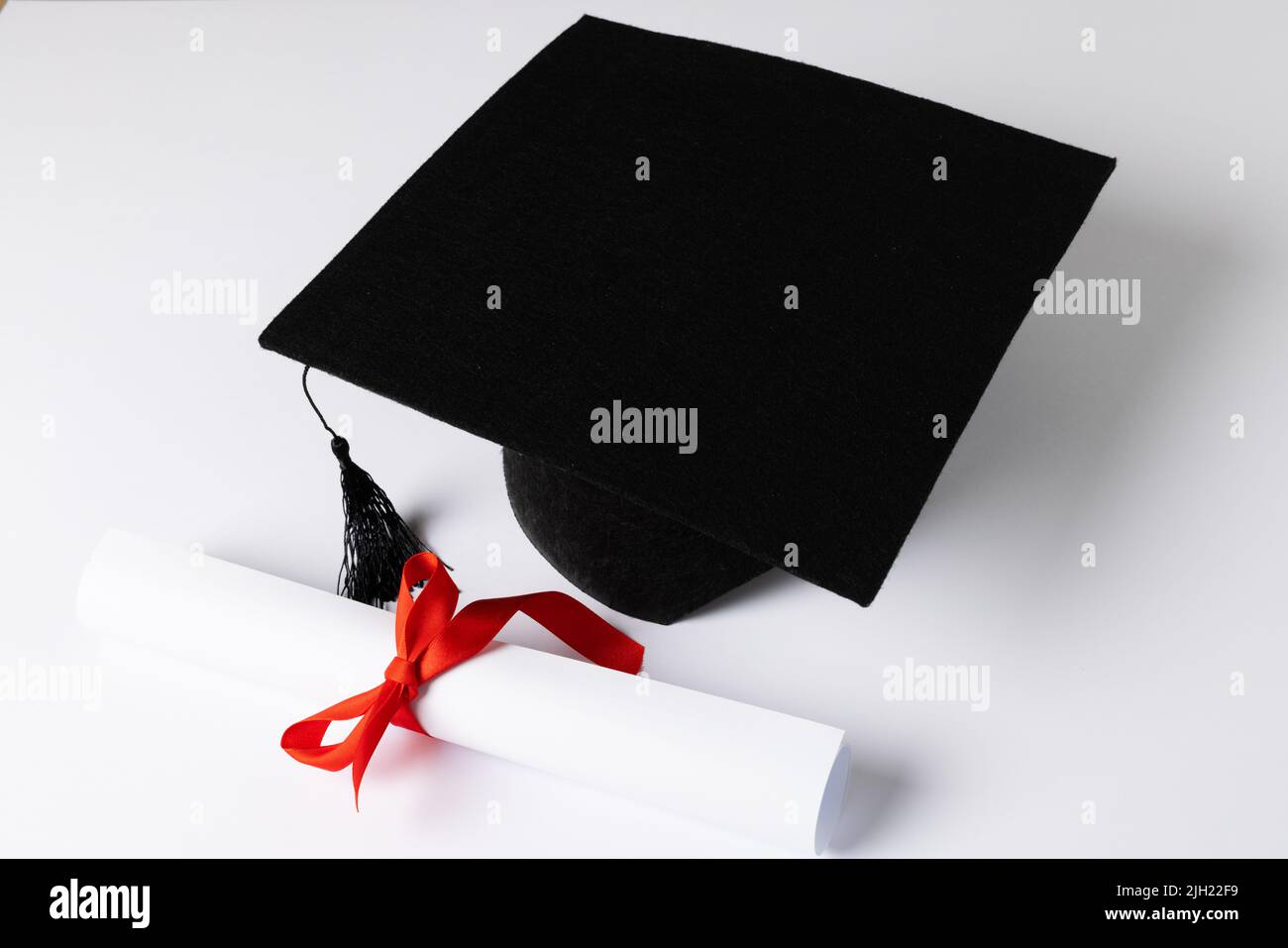 Image of graduation hat and diploma on white surface Stock Photo - Alamy