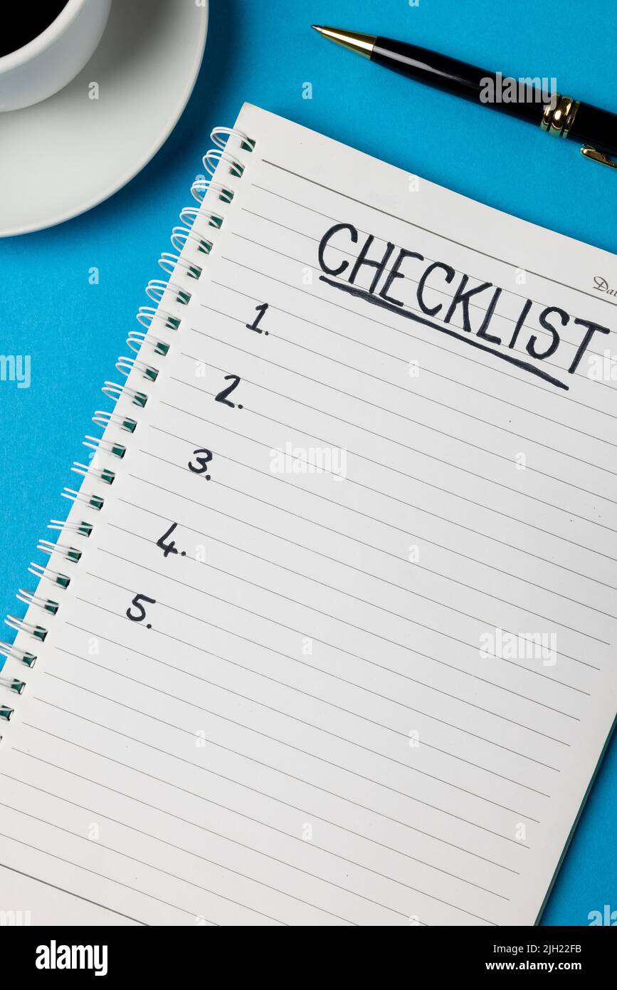 Vertical image of notebook with checklist and copy space, coffee and ...