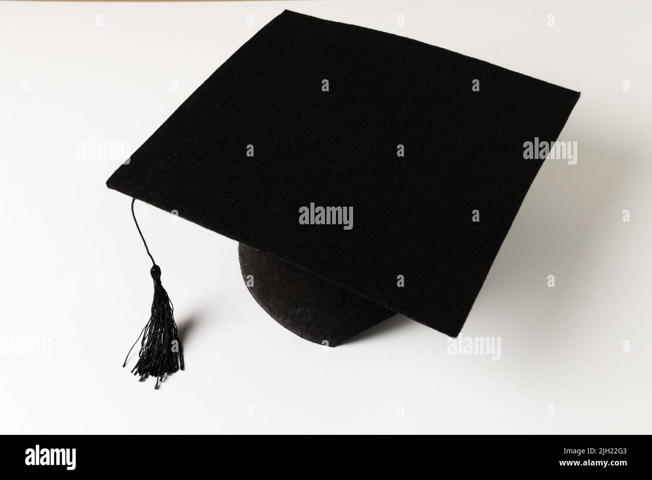 Image of black graduation hat lying on white surface Stock Photo - Alamy