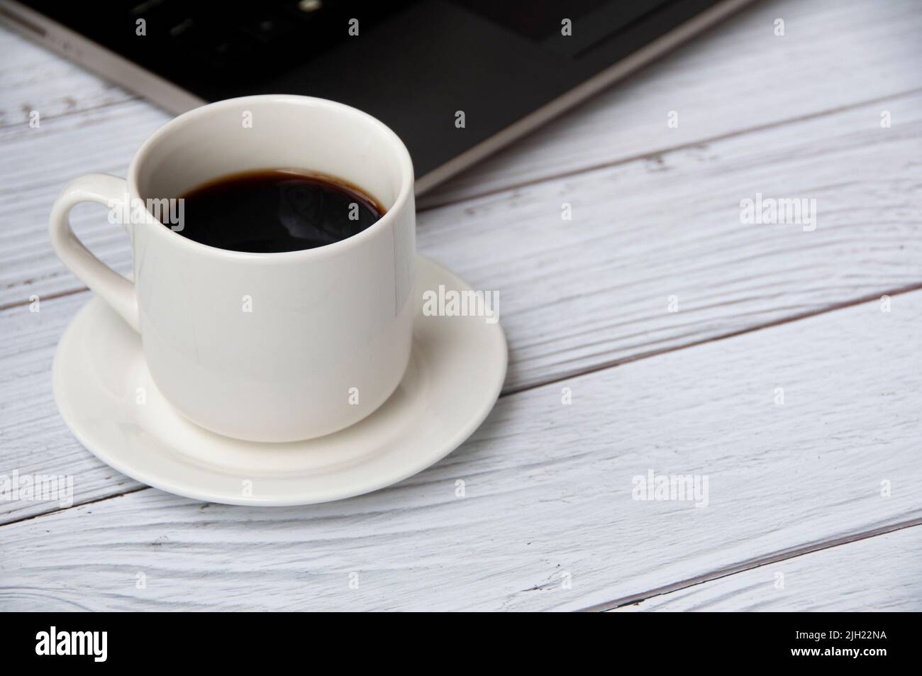 Coffee cup and laptop on wooden table with customizable space for text ...