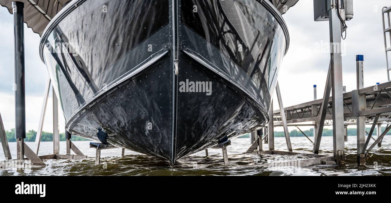 Boat with a hydraulic dock lift sitting above the water line on a lake ...
