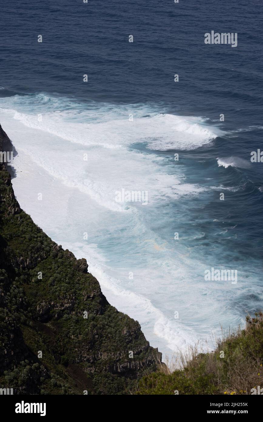 The vertical view of sea waves hitting the cliffs - good match for ...