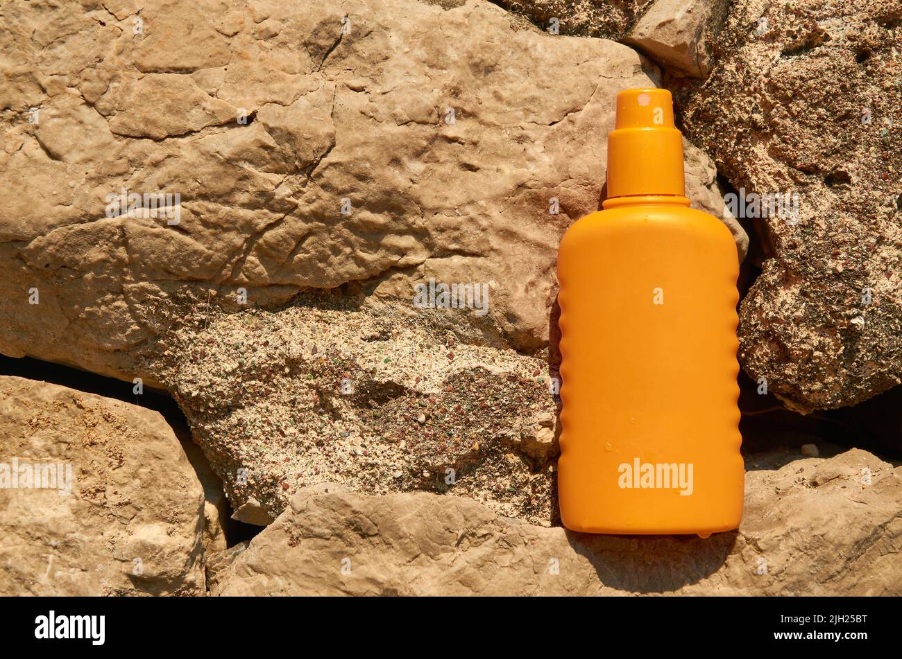 Orange container of a sun protection cream on a stone background Stock ...