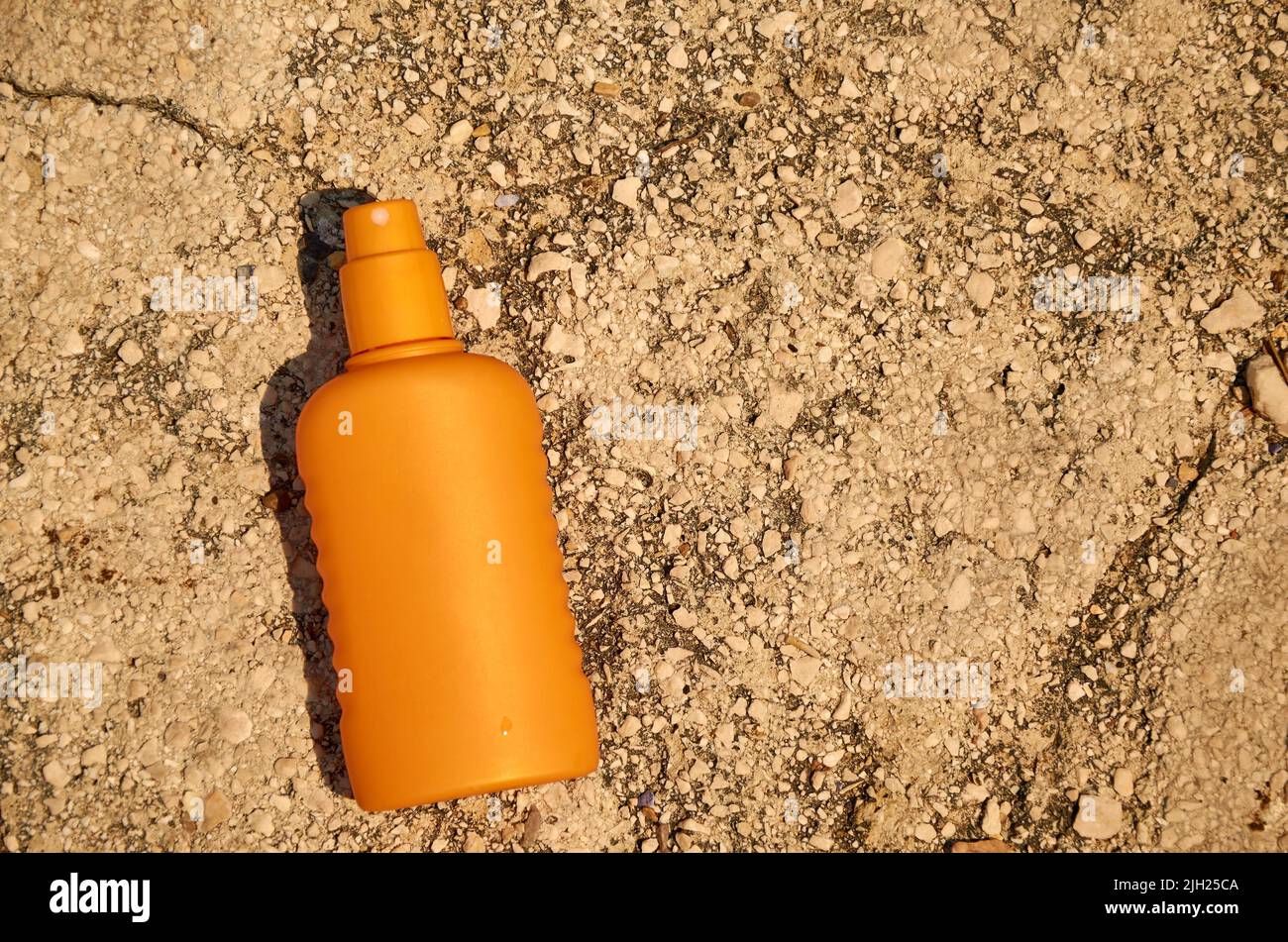 Orange container of a sun protection cream on a stone - surface ...