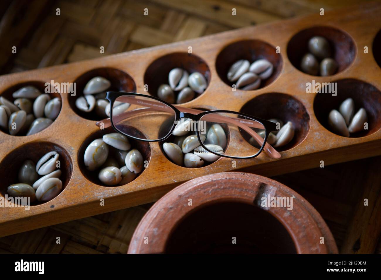 Congklak, a traditional game that uses a wooden board with 14 to 16 ...