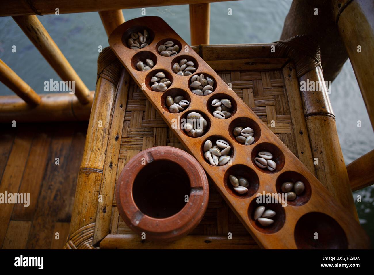 Congklak, a traditional game that uses a wooden board with 14 to 16 ...