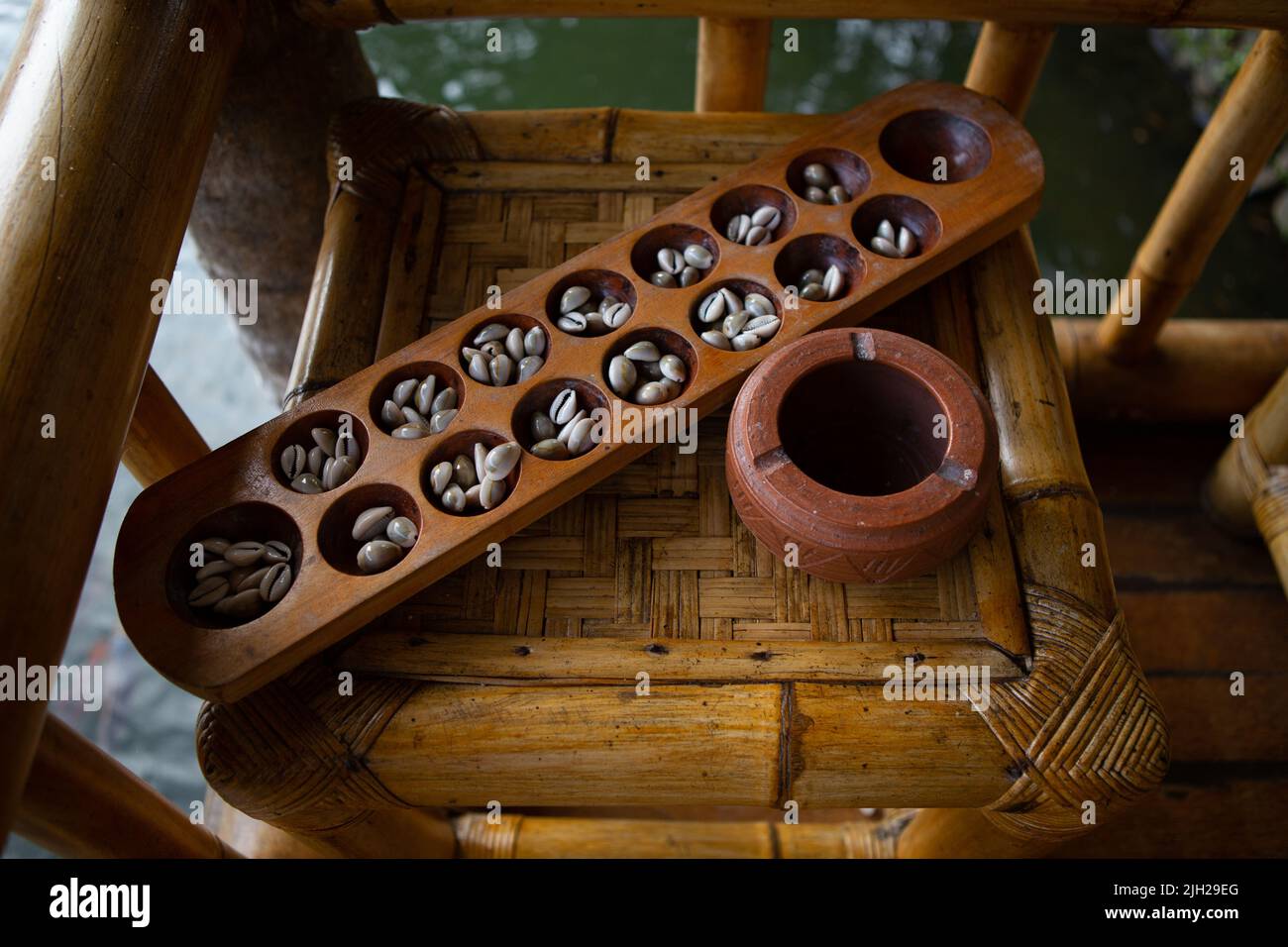 Congklak, a traditional game that uses a wooden board with 14 to 16 ...