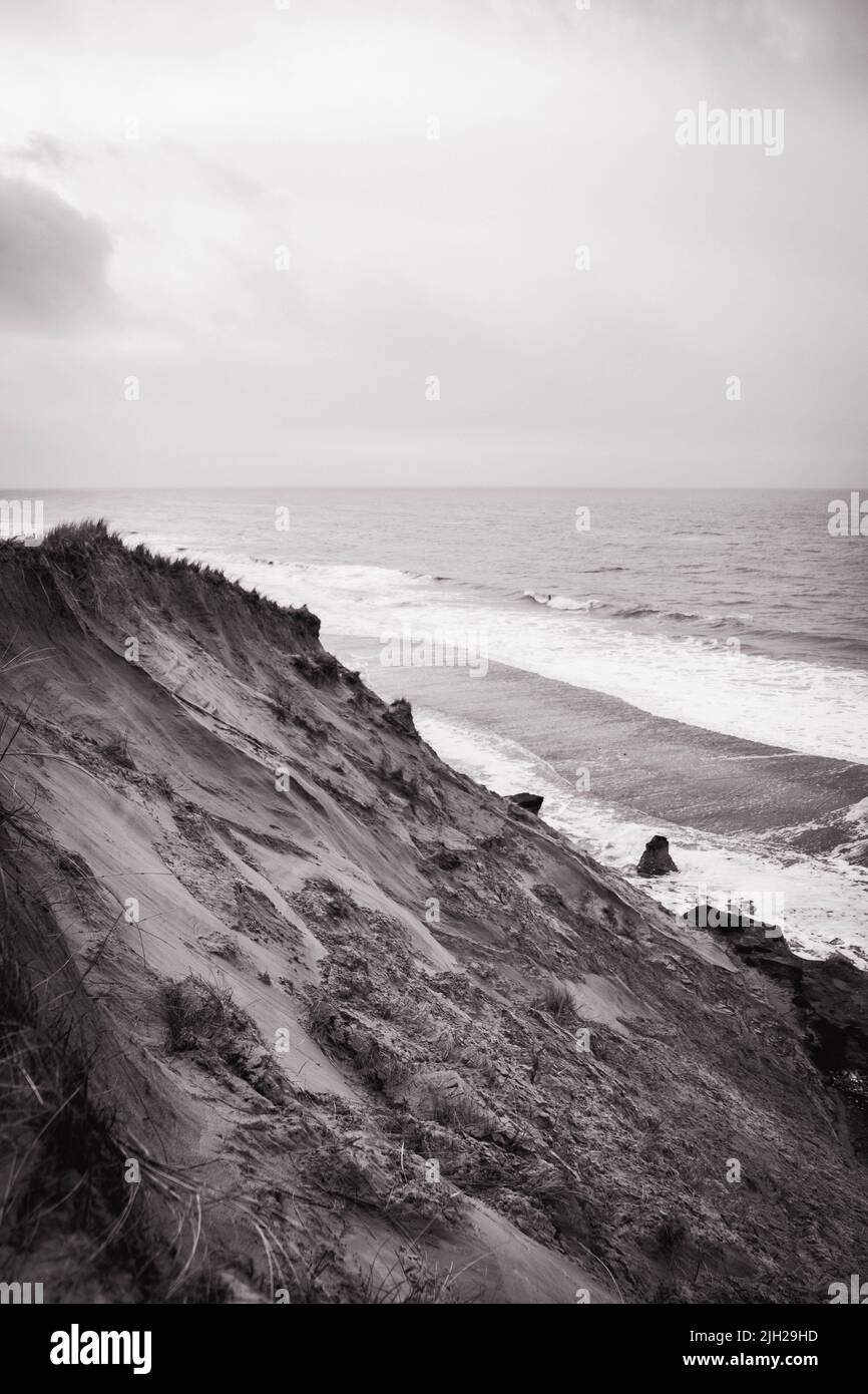 A grayscale of a rocky and wavy beach Stock Photo - Alamy