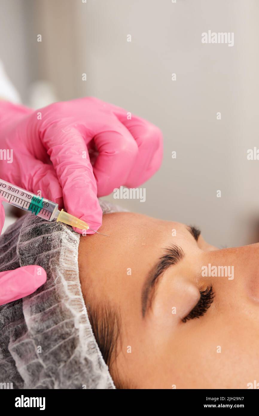 Portrait of young Caucasian woman getting botox cosmetic injection in ...