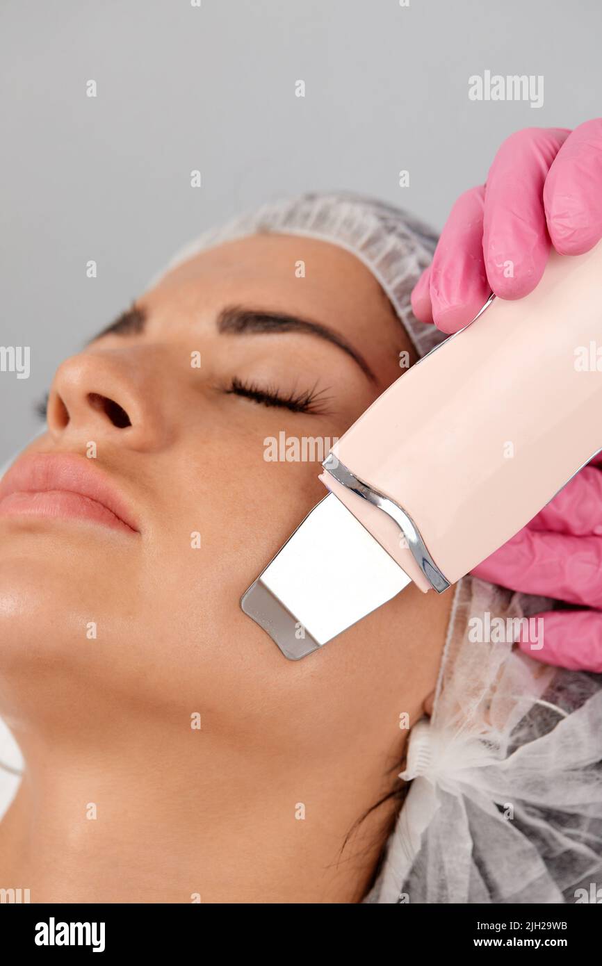 Cosmetologist Beautician In Pink Gloves Making Facial Treatment With