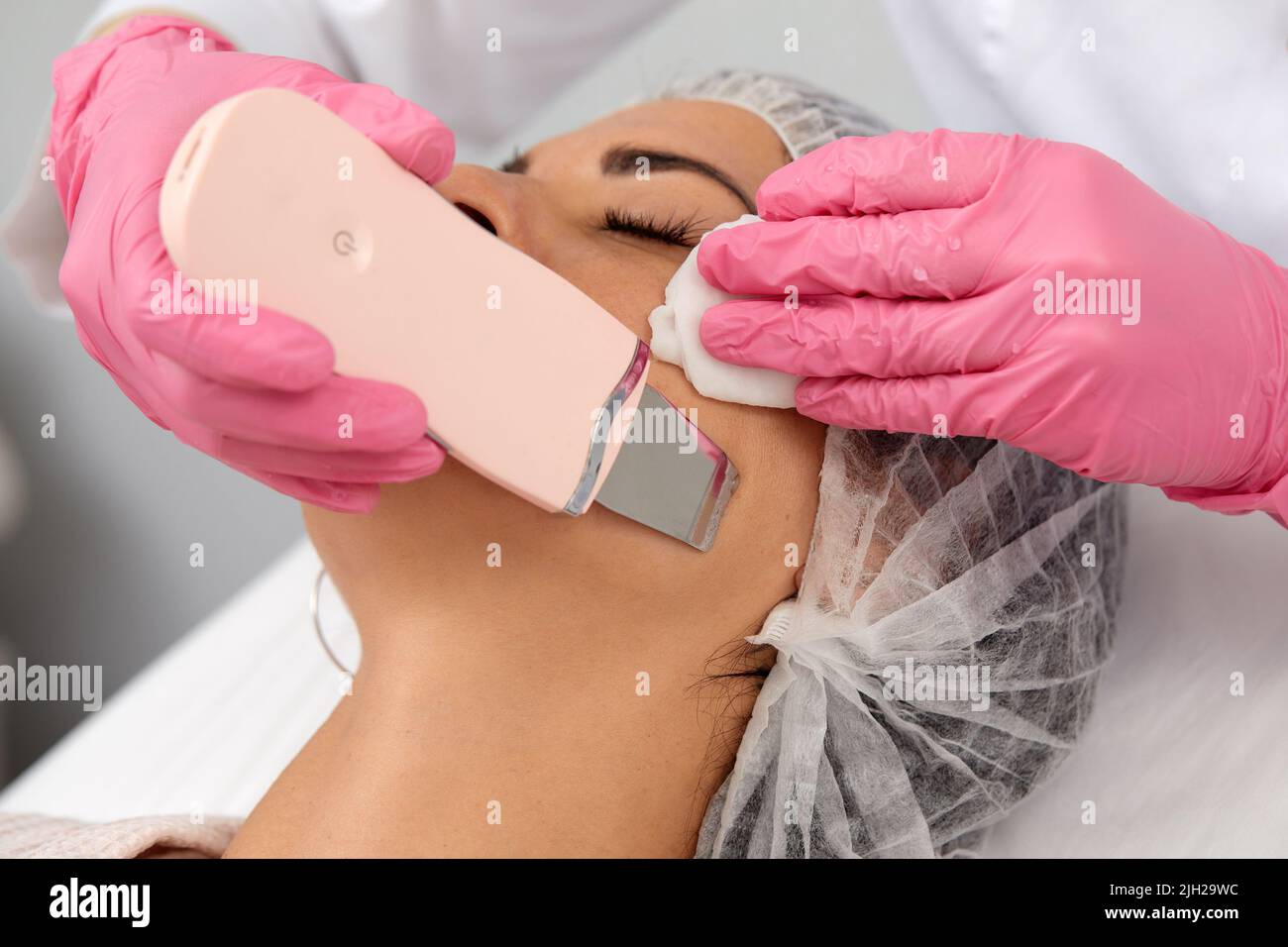 Cosmetologist Beautician In Pink Gloves Making Facial Treatment With