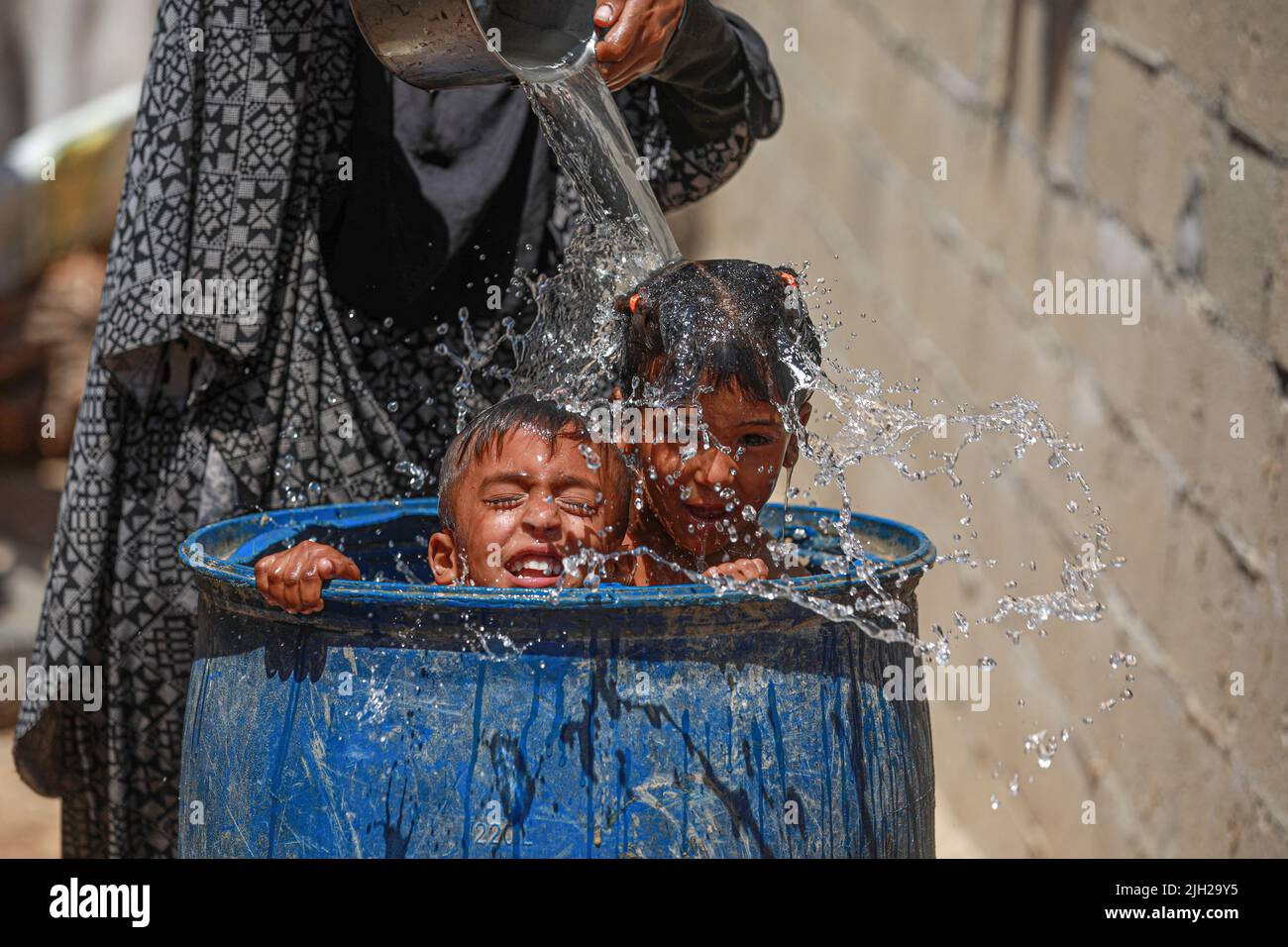 Gaza City, Palestine. 14th July 2022. A Palestinian mother showering ...
